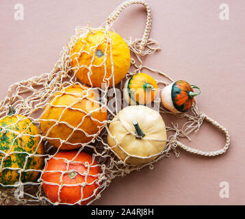 Pumpkins in string shopping bag on wooden background. Copy space for ...