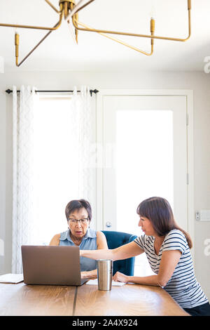 Parent and child bonding together in front of laptop computer. Ethnic ...