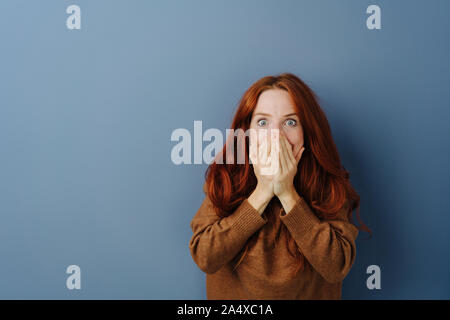 Horrified young woman staring wide-eyed at her tablet Stock Photo - Alamy
