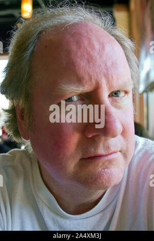 Close-up of skeptical middle-aged man, frowning and looking doubtful at ...