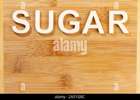 The word "sugar" written with sugar cane on white sugar background ...
