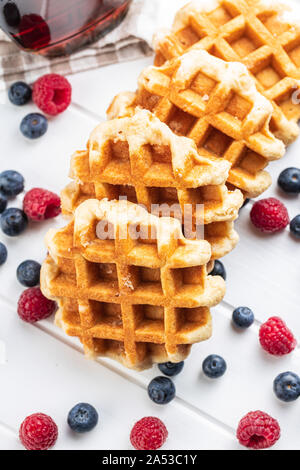 round belgian waffles on a white plate on a rustic wooden table Stock ...