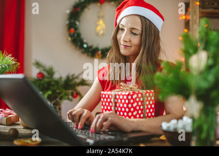 Red gift box and computer laptop on white background, top view, copy ...
