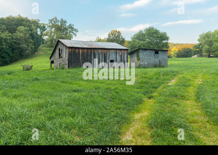 Red corn crib barn on fall day sheltering an old wagon with tree ...