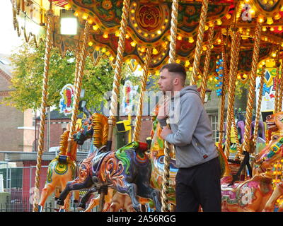 Funfair worker; Fairground ride operator UK, standing by a fun fair ...