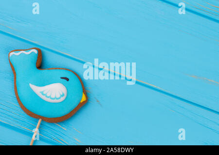 Blue bird shaped biscuit. Cookie on stick, wooden background. Flavor of ...