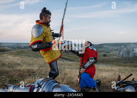 Medieval knight in armor prepares to cut off head Stock Photo - Alamy