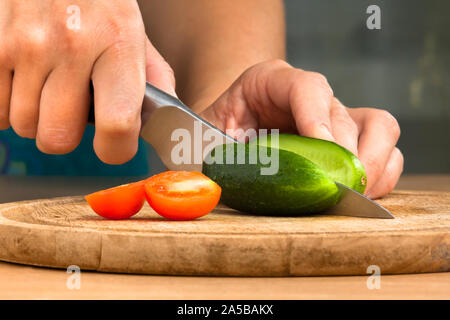 Closeup female hands cutting cucumber on cutting board Stock Photo - Alamy
