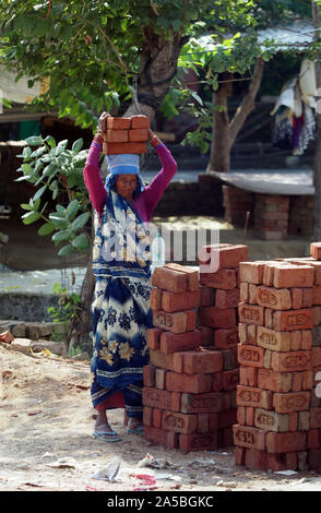 A woman carrying bricks on her head at a construction site in Ahmedabad ...