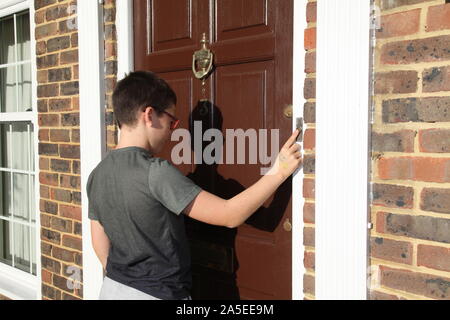 Young boy ringing doorbell Stock Photo - Alamy
