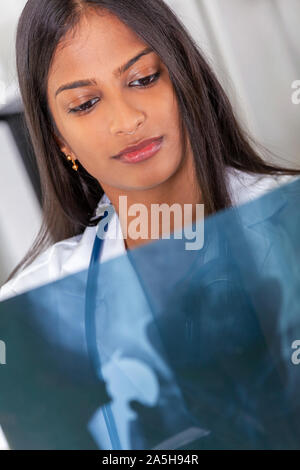 Young Asian female doctor examining anatomical brain model during ...
