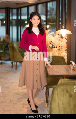 Woman standing next to table in restaurant Stock Photo - Alamy