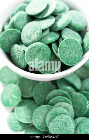 Green round chocolate chips for melting chocolate shapes on a white ...