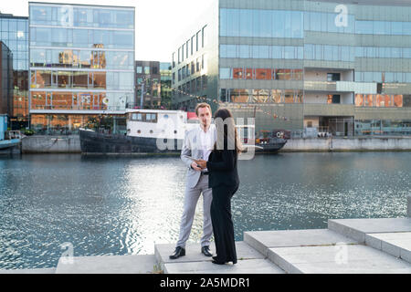 Business people outdoor meeting. Male employees in suits communicate ...