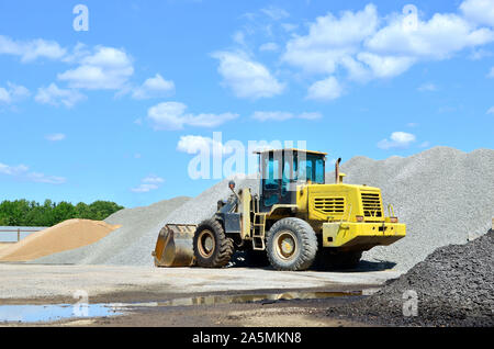 Front loader loading sand and stones to the rock crusher / separator ...