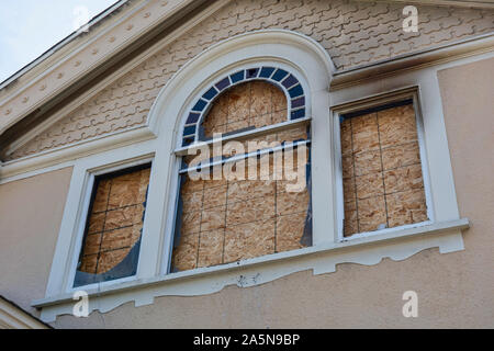 house or home fire - boarded up windows and burned facade blackened by ...