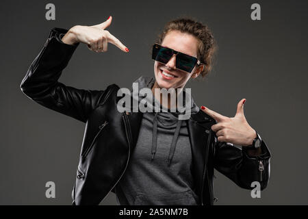 A young girl with rough facial features in a black jacket screams on ...