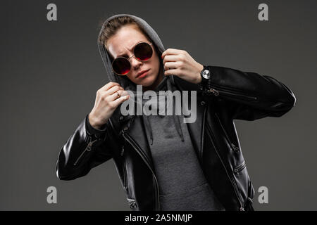A young girl with rough facial features in a black jacket screams on ...