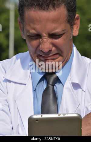 Confused Male Hispanic Doctor Using Tablet Stock Photo - Alamy
