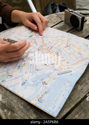 Close-up of unrecognizable tourist checking notes before travel, straw ...