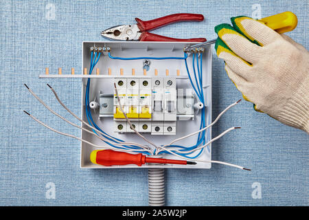 Technician installing a new switchboard with automatic fuses for ...
