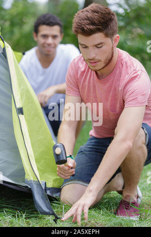 young man setting up camp tent for camping Stock Photo - Alamy
