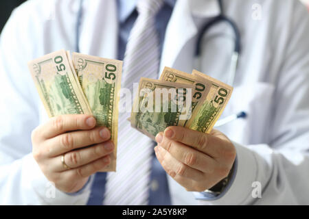 Rich doctor man counting money. Handsome medical health care worker in ...