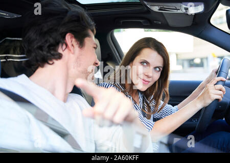 Female driver finger pointing direction, woman driving a car, retro ...