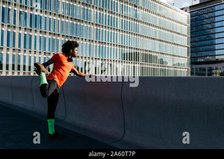 Young hispanic man stretching at sport center Stock Photo - Alamy