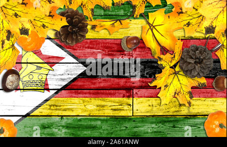 Zimbabwe flag on autumn wooden background with leaves and good place ...