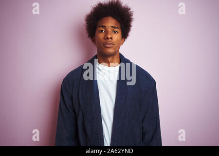 Afro american man wearing pajama drinking coffee standing over isolated ...