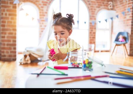 Beautiful toddler playing with wooden building blocks on the table at ...