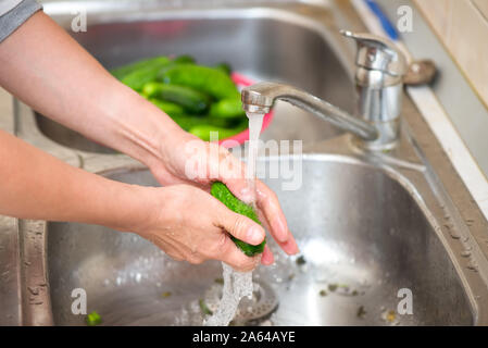 Woman washing cucumbers in kitchen sink Stock Photo - Alamy
