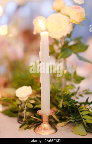 Stylish candle on table near white wall Stock Photo - Alamy