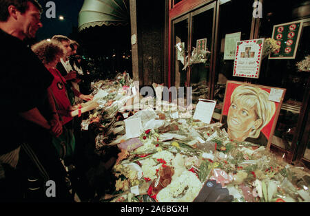 Flowers and mourners outside Harrods department store, looking at ...