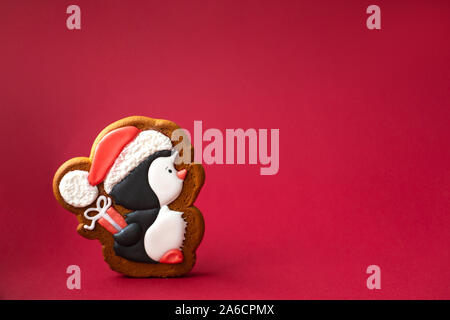 gingerbread cookie of cute penguin with gift on blue background ...
