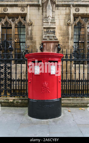 A traditional red double fronted Royal Mail post box with boxes ...