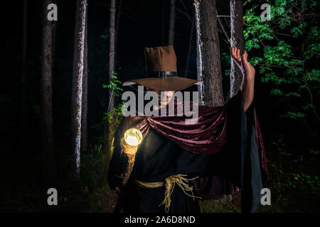 Man who is wearing wizard robes and casting glow spell with his magic ...