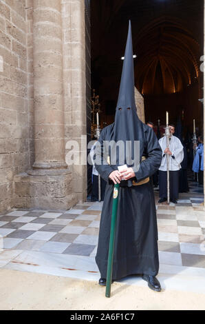 A religious brotherhood wearing penitential robes and conical hoods for ...