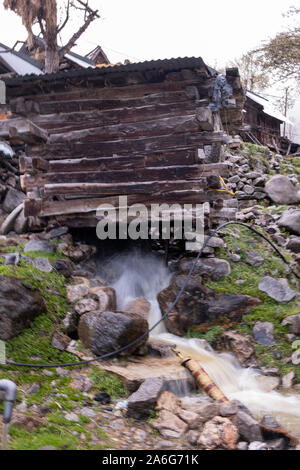 A flour mill that runs on a stream of water. The water rotates the ...