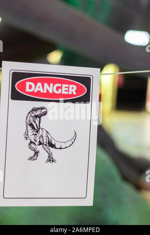 dinosaur sign danger zone symbol caution safety wild Stock Photo - Alamy