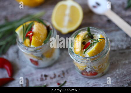 Fermented lemons in jars of salt, chili pepper and rosemary. Probiotics ...