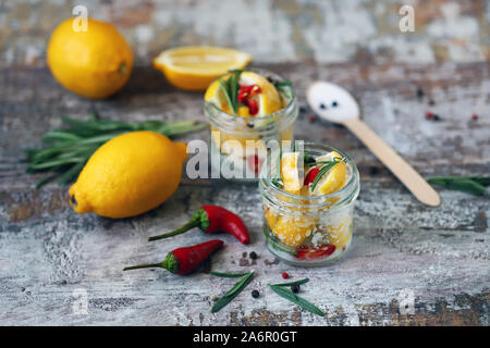 Fermented lemons in jars of salt, chili pepper and rosemary. Probiotics ...