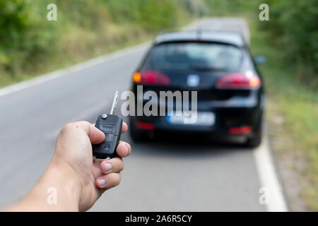 Picture of the man holding car key, opening his brand new black car ...