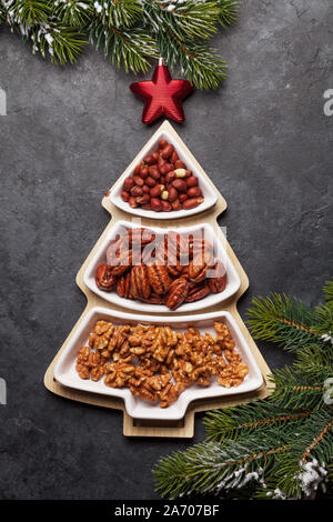 Christmas greeting card with various nuts in fir tree shaped box and ...