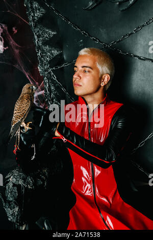 Young man in halloween wizard costume standing in dark forest with ...