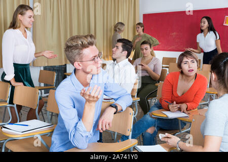 Smiling adult students communicating during recess between lectures at ...