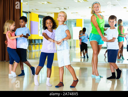 Diligent smiling positive children dancing together slow ballroom ...