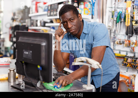 portrait of positive experienced salesman of household store offering ...