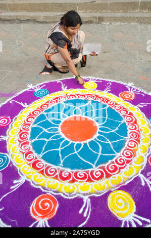 Young India woman making a Rangoli design at Sankranthi festival ...